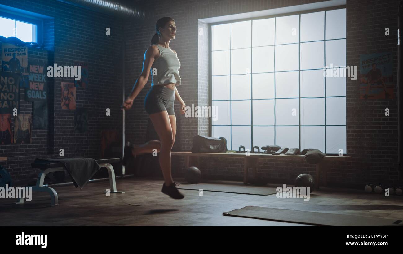 Strong Athletic Woman Exercises with Jumping Rope in a Loft Style ...