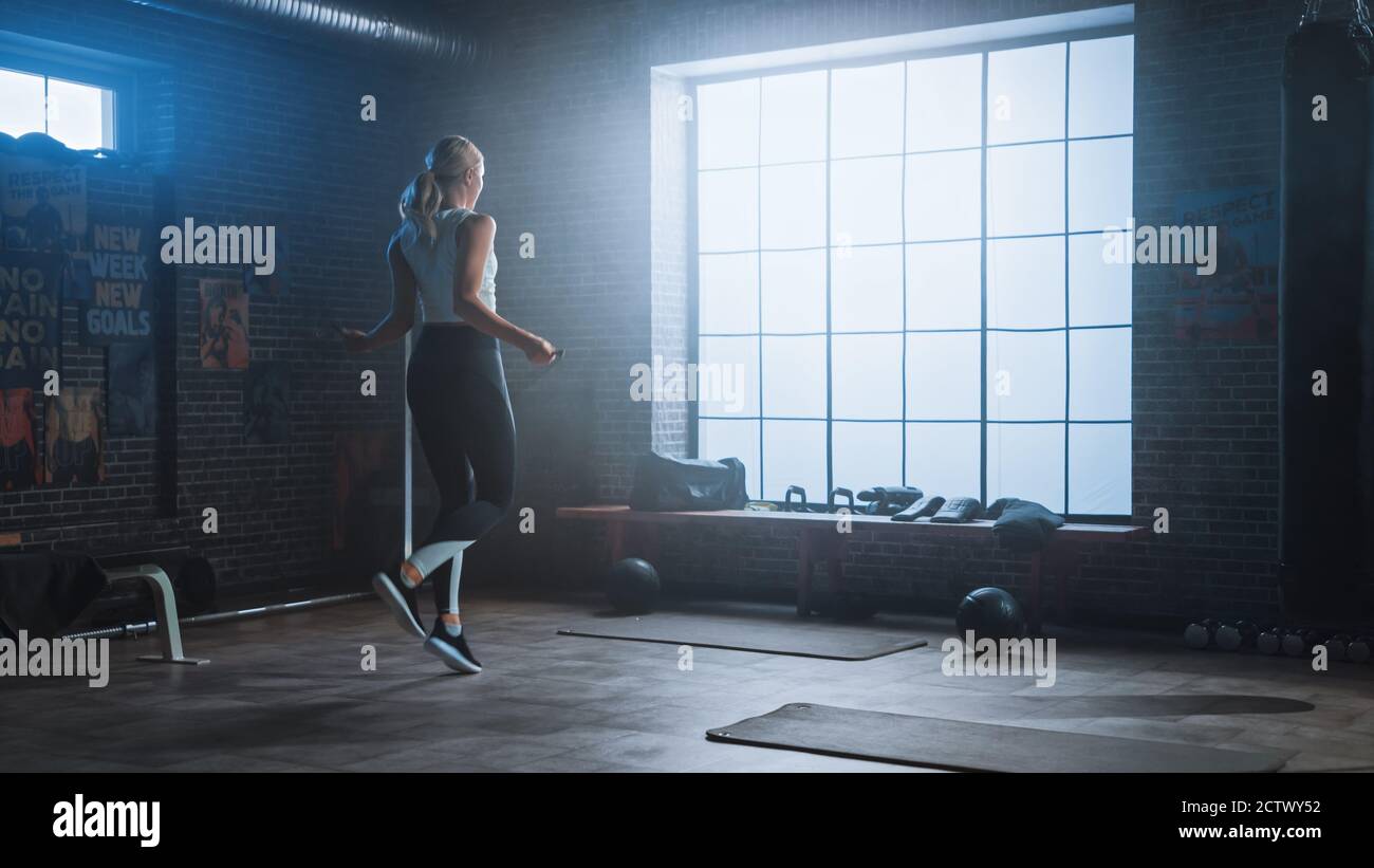 Fit Athletic Blond Woman Exercises with Jumping Rope in a Loft Style ...