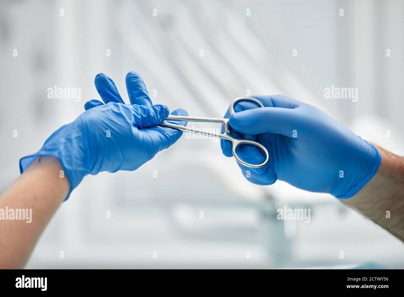 Close-up of the hands of a dentist and nurse surgeon over an operating ...