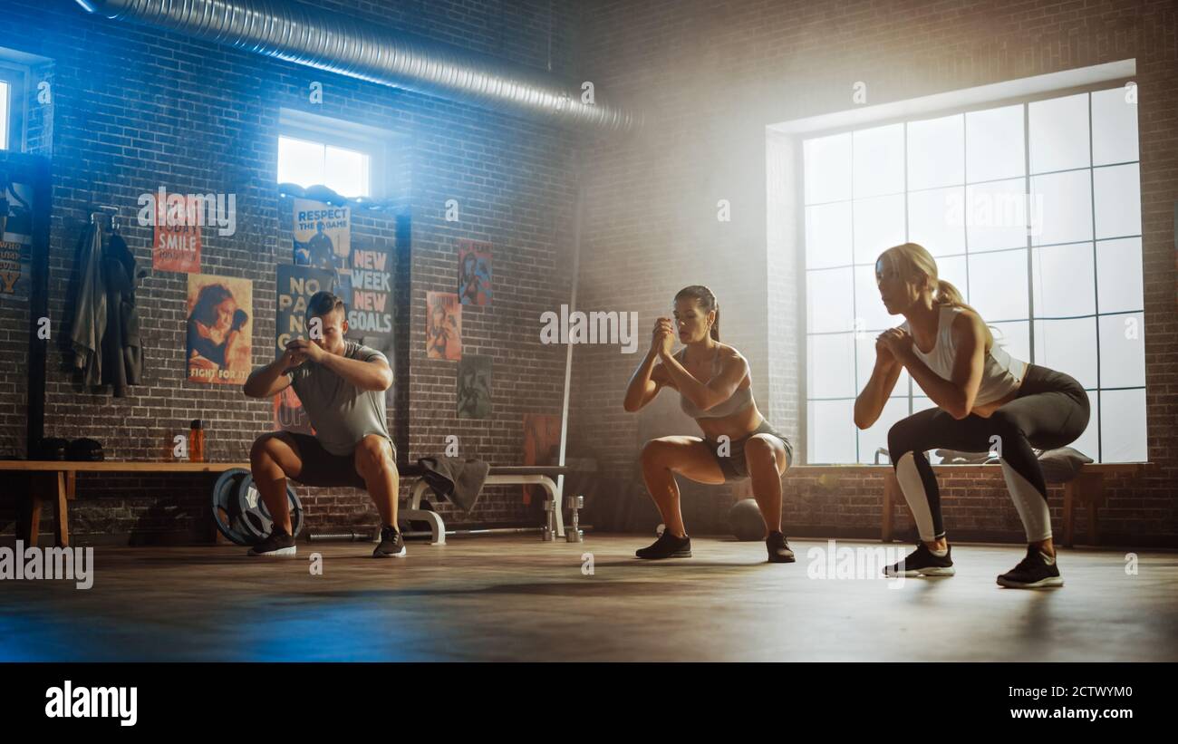 Strong Masculine Man and Two Fit Athletic Women are Doing Squat ...