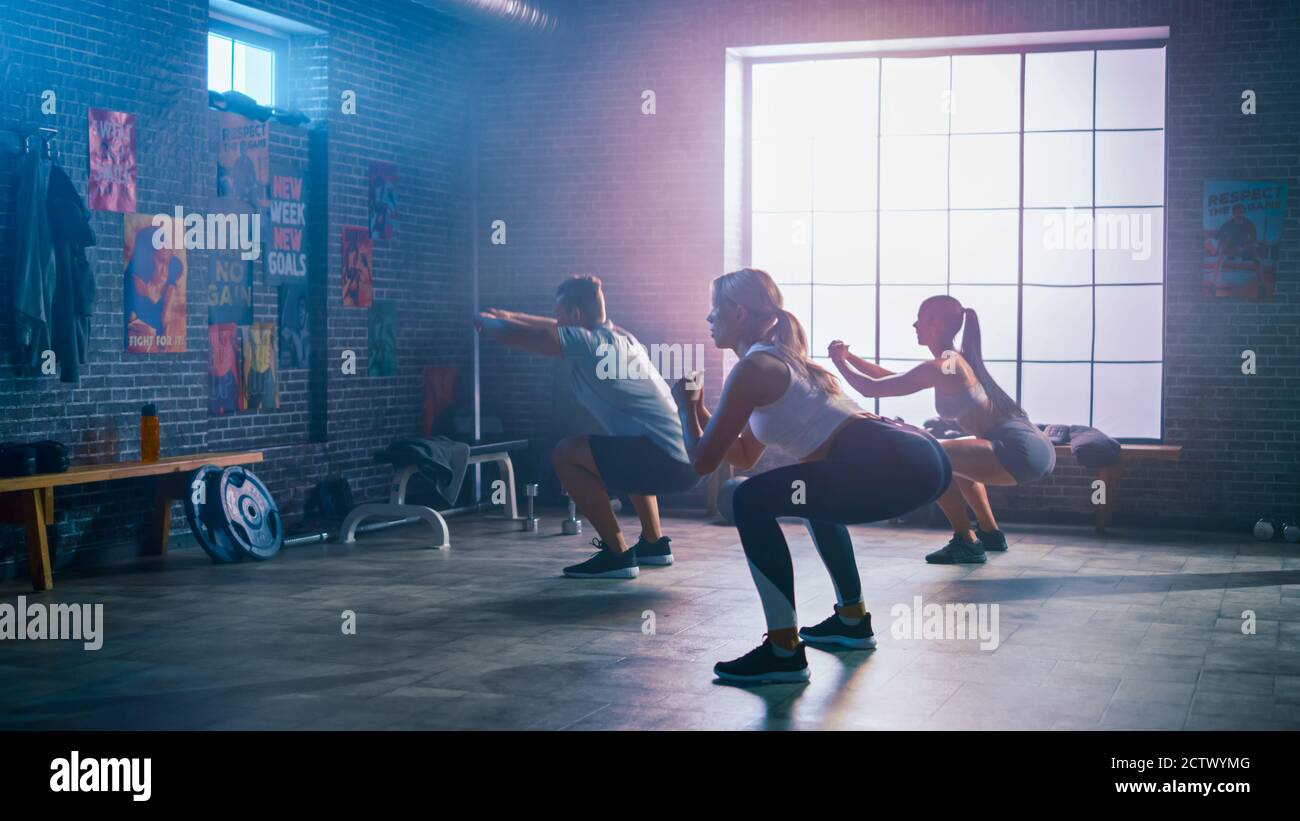 Strong Masculine Man and Two Fit Athletic Women are Doing Squat ...