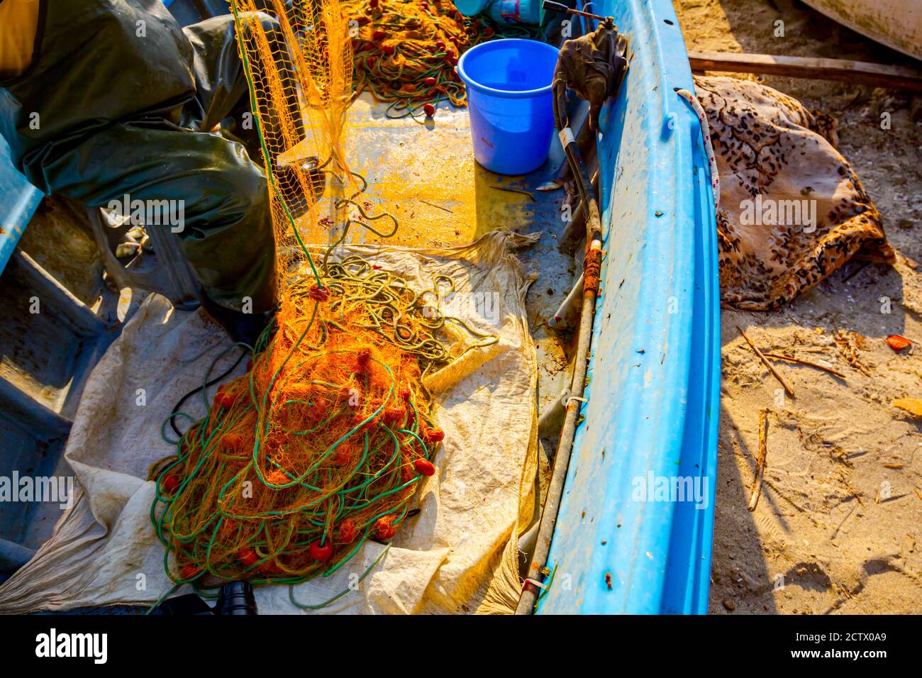 Fisher in rubber trousers and boot is sitting in his boat and pile up ...