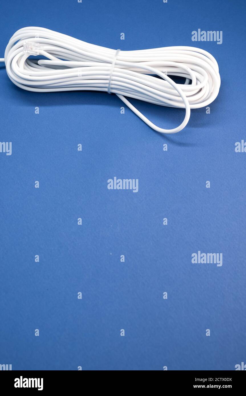 Vertical shot of an electrical extension cord isolated on a blue ...