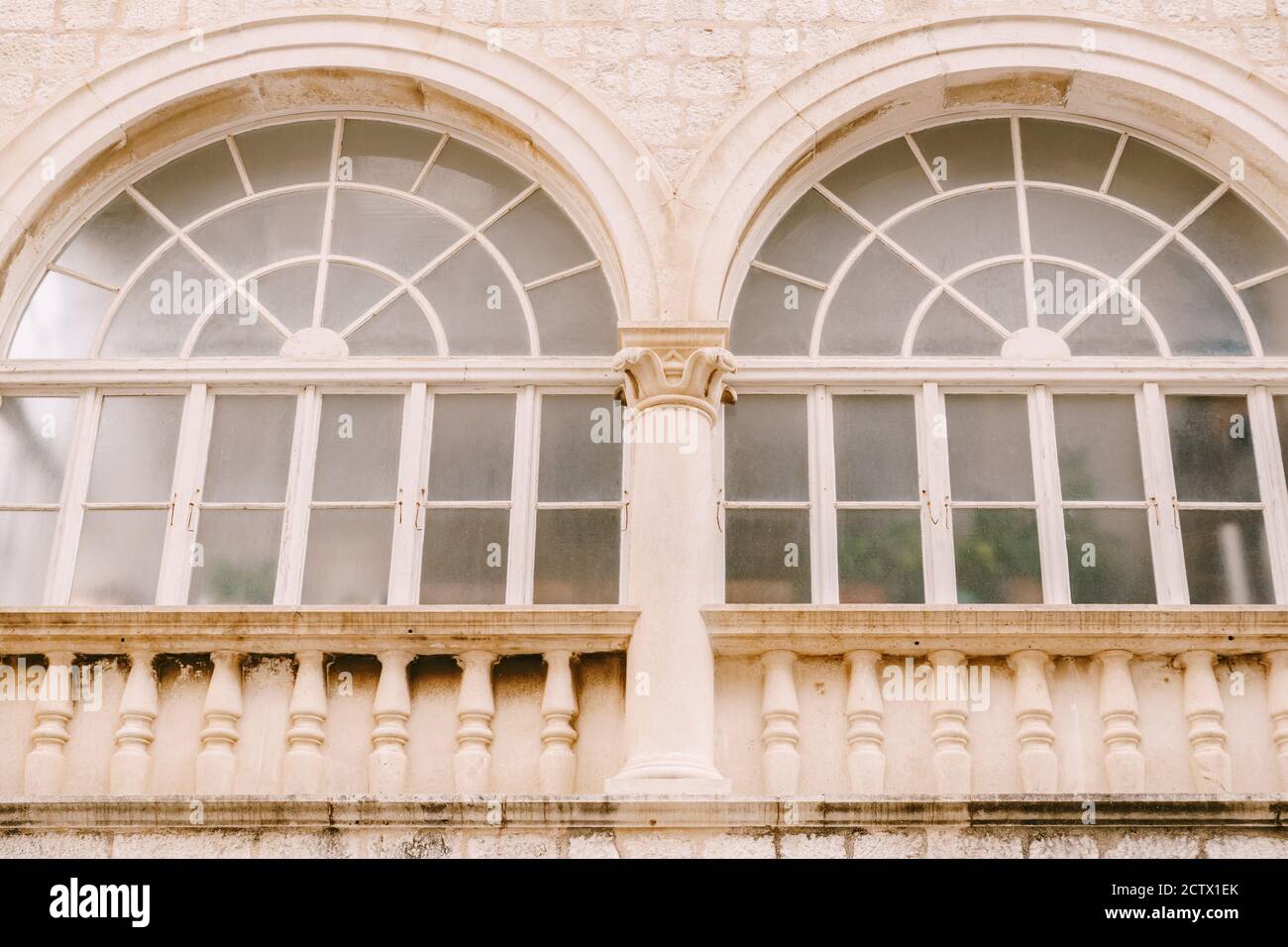 Close-up of white arched windows on a patterned building by the ...