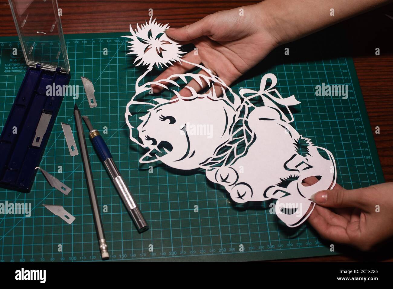 cutting paper patterns snowing with a knife on a special rug. snowman ...