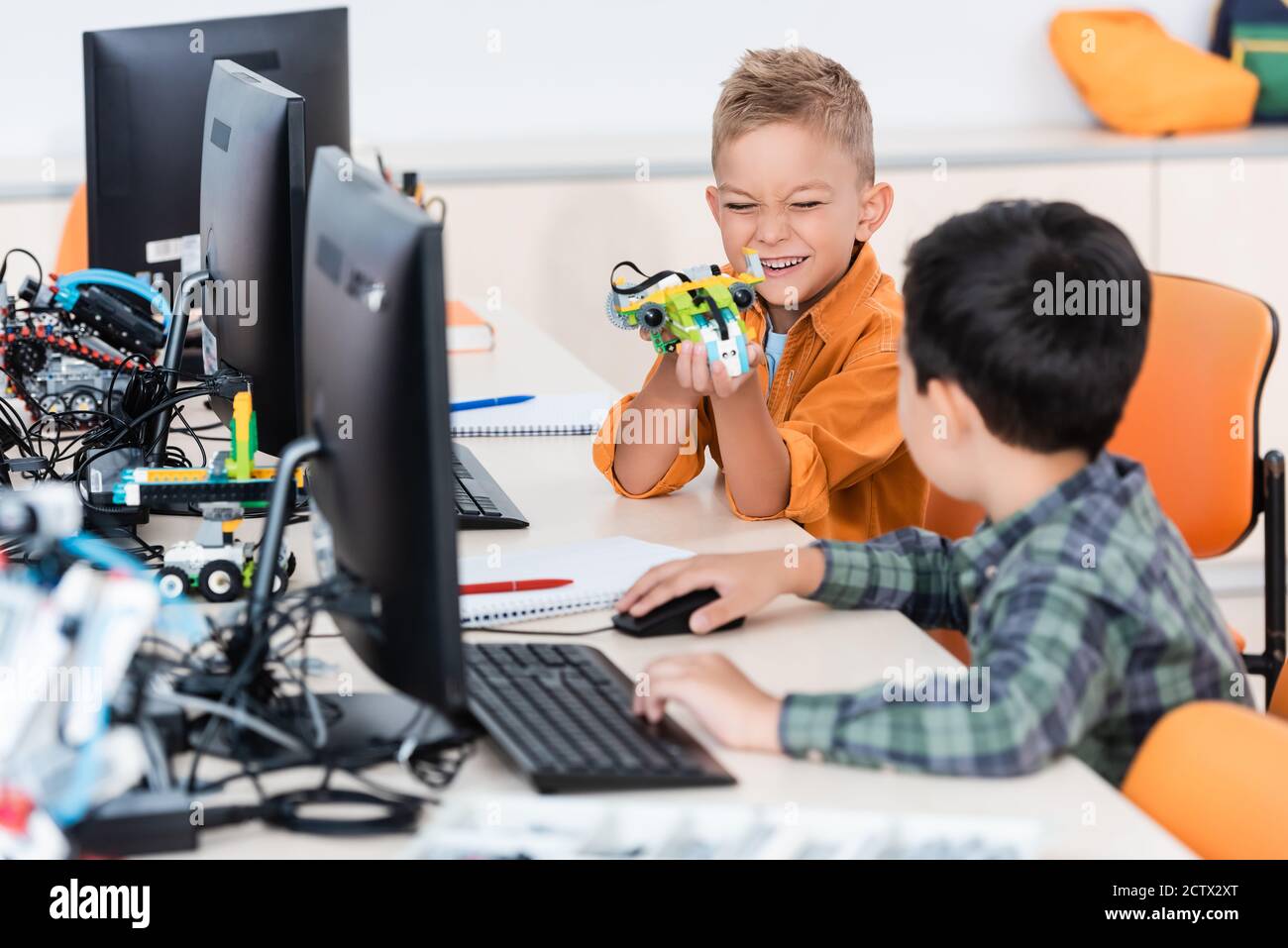 Selective focus of multiethnic schoolings playing with robot near ...