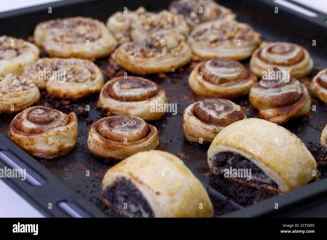 Baked buns stuffed with poppy, cinnamon and walnuts. Lie on a baking ...