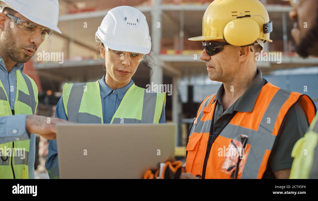 Diverse Team of Specialists Use Laptop Computer on Construction Site ...