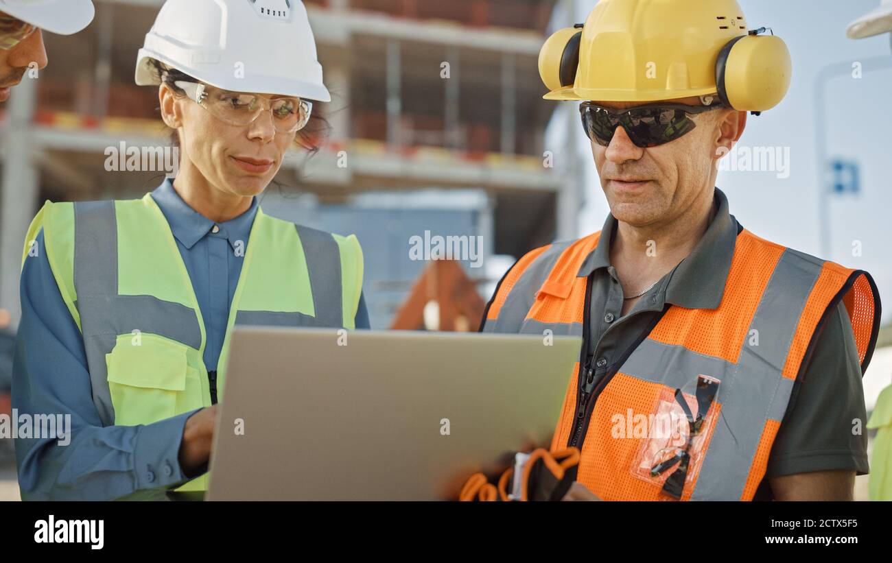 Diverse Team of Specialists Use Laptop Computer on Construction Site ...
