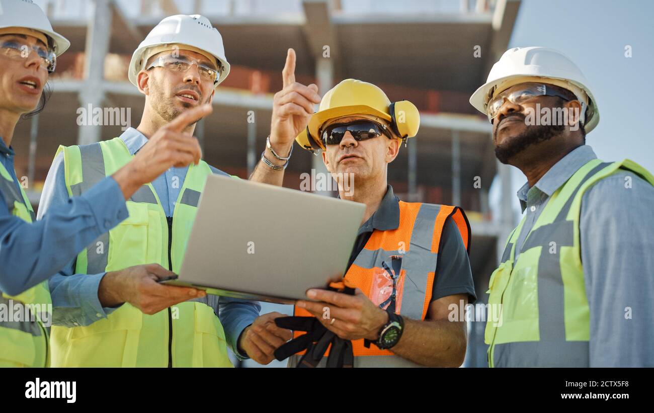 Diverse Team of Specialists Use Laptop Computer on Construction Site ...