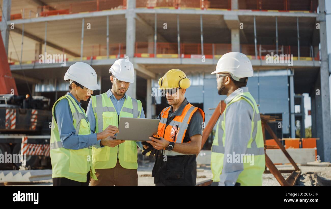 Diverse Team of Specialists Use Laptop Computer on Construction Site ...
