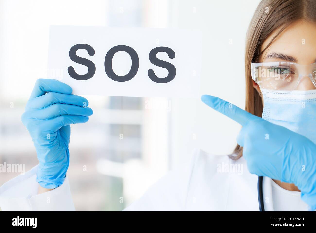 The doctor holds a form with the text sos Stock Photo - Alamy