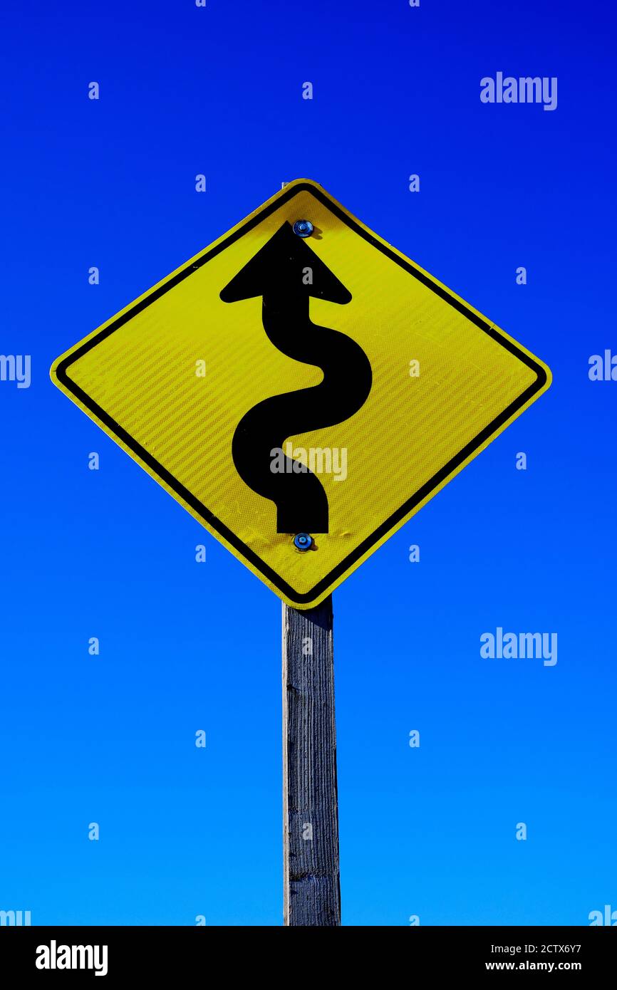 Curves ahead on roadsign road sign bright yellow on blue sky Stock ...