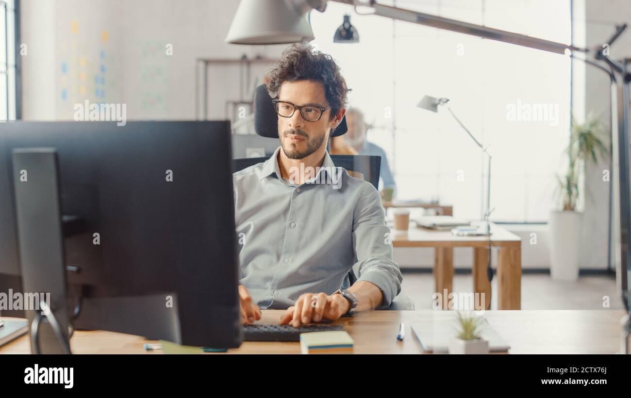 Handsome and Smart Hispanic Office Employee Sitting at His Desk Works ...