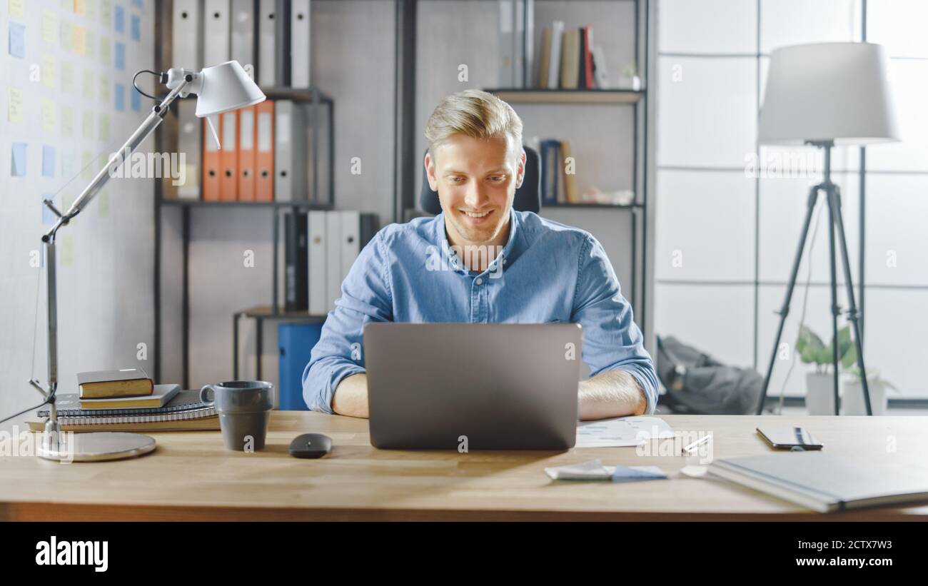 Creative Entrepreneur Sitting at His Desk Works on a Laptop in the ...