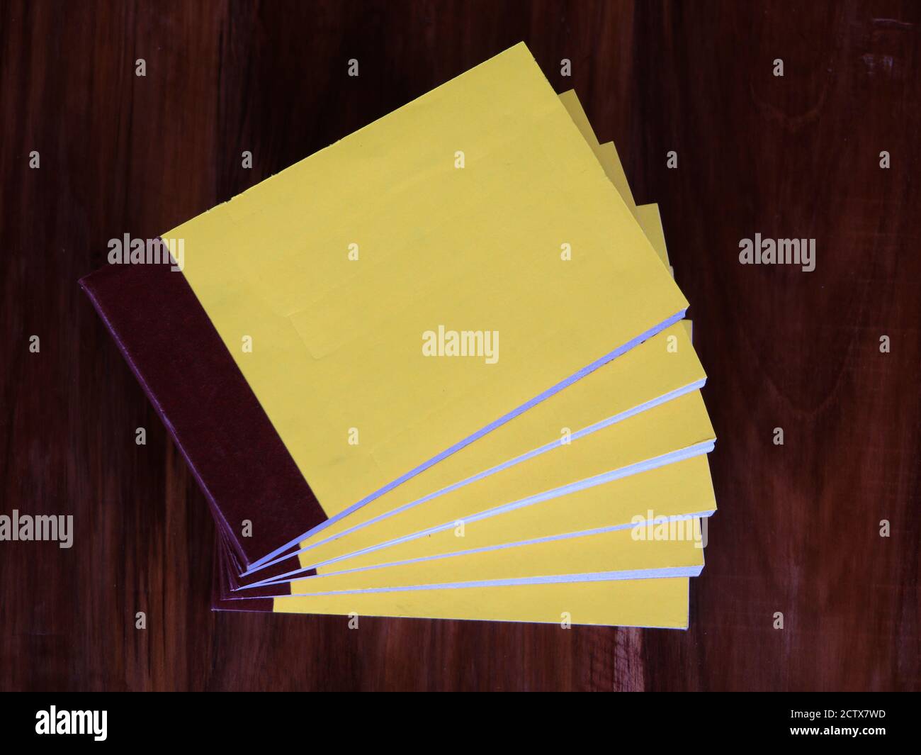 Yellow color bill books or receipt books on a wooden surface, close up ...