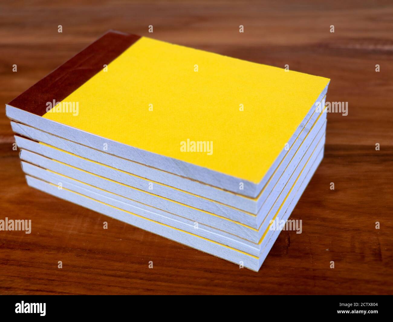 Yellow color bill books or receipt books on a wooden surface, close up ...