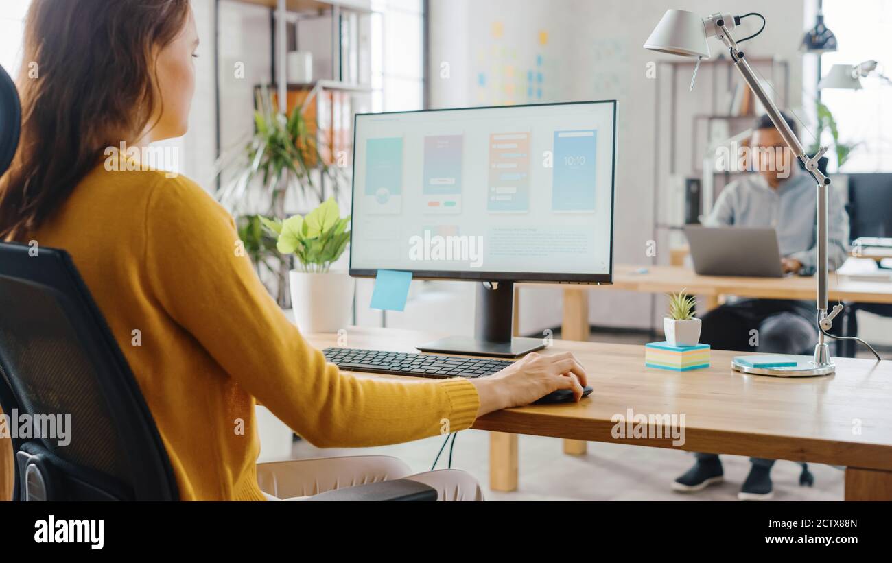 Over the Shoulder: Female Mobile Software Developer Sitting at Her Desk ...