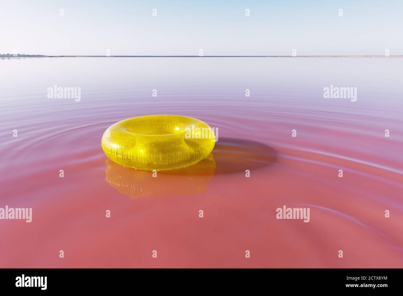 Bright yellow inflatable ring float in pink water lake. Creative color ...