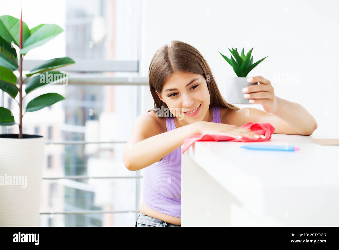 Cleaner tidies up the computer desk in the office Stock Photo - Alamy