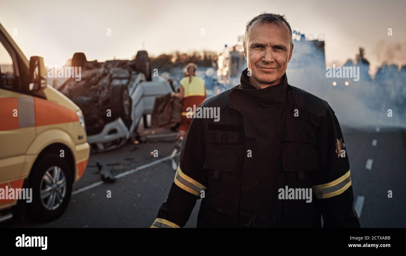 Portrait of the Brave Firefighter Smiling on Camera. In the Background ...