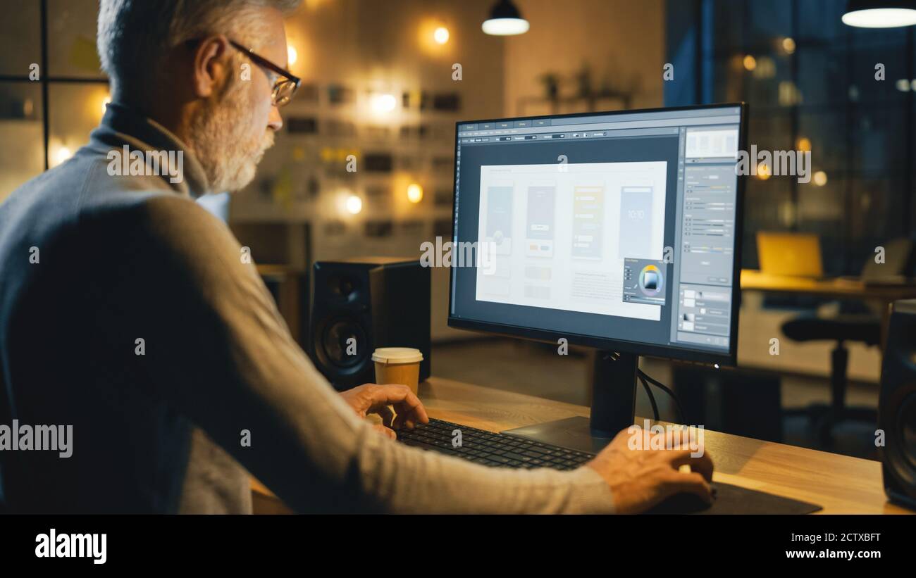Creative Middle Aged Mobile Software Designer Sitting at His Desk Uses ...