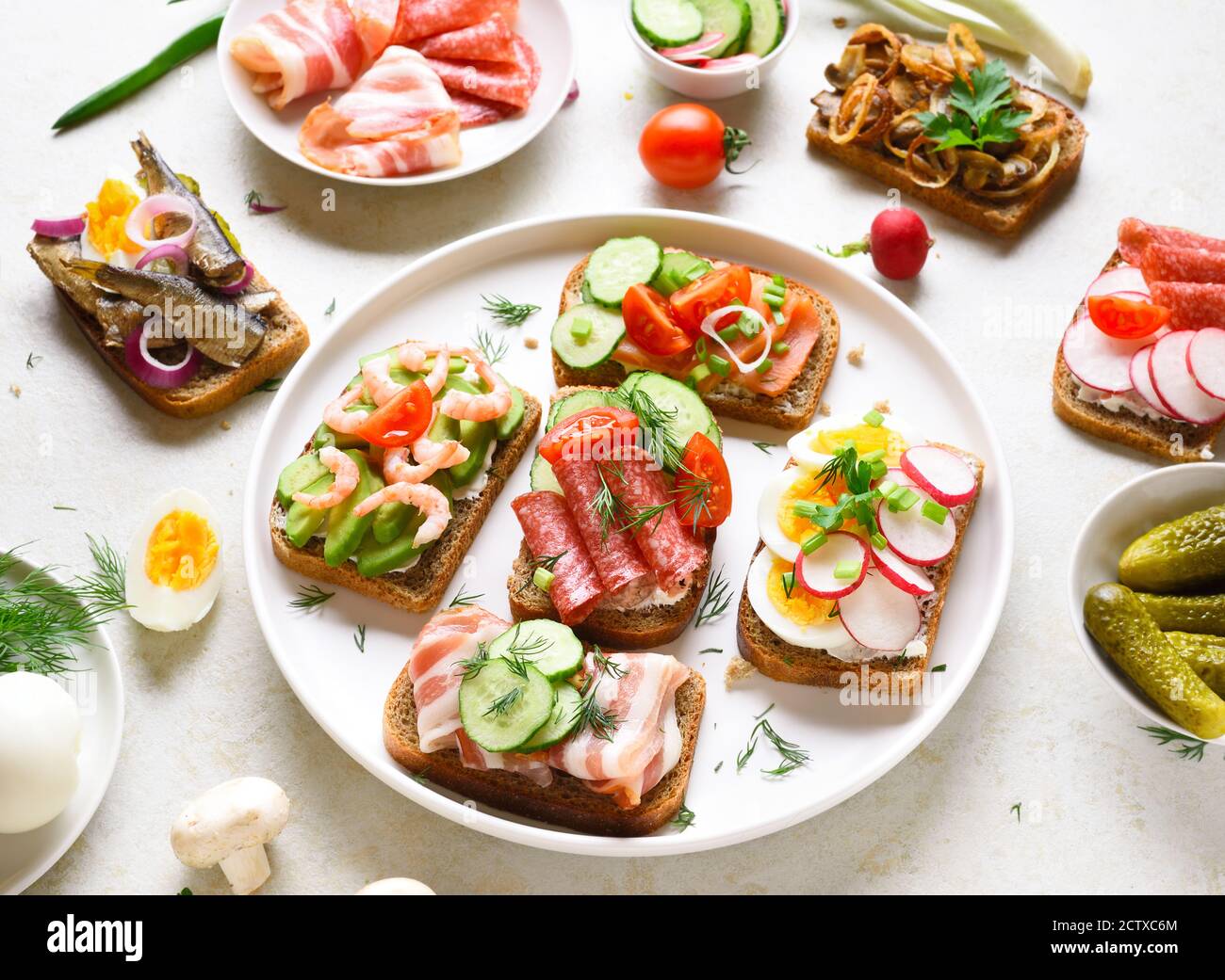 Open sandwiches with meat, vegetables, seafood on light stone ...