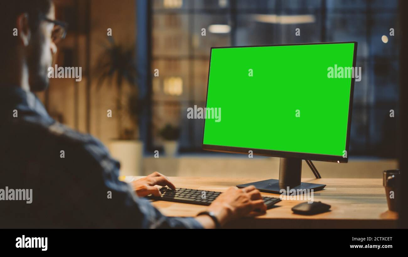 Over the Shoulder: Creative Young Man Sitting at His Desk Using Desktop ...