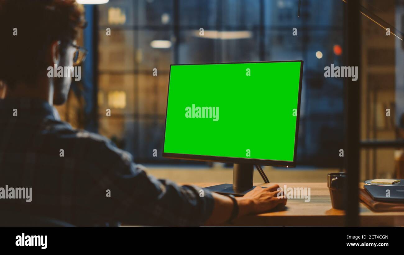 Over the Shoulder: Creative Young Man Sitting at His Desk Using Desktop ...