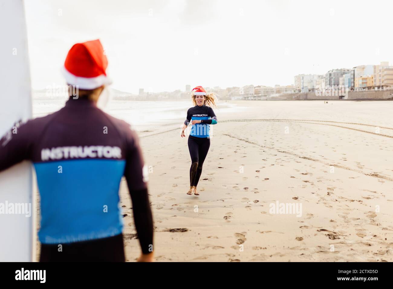 Two surf instructors couple meet at the beach with their surfboard ...