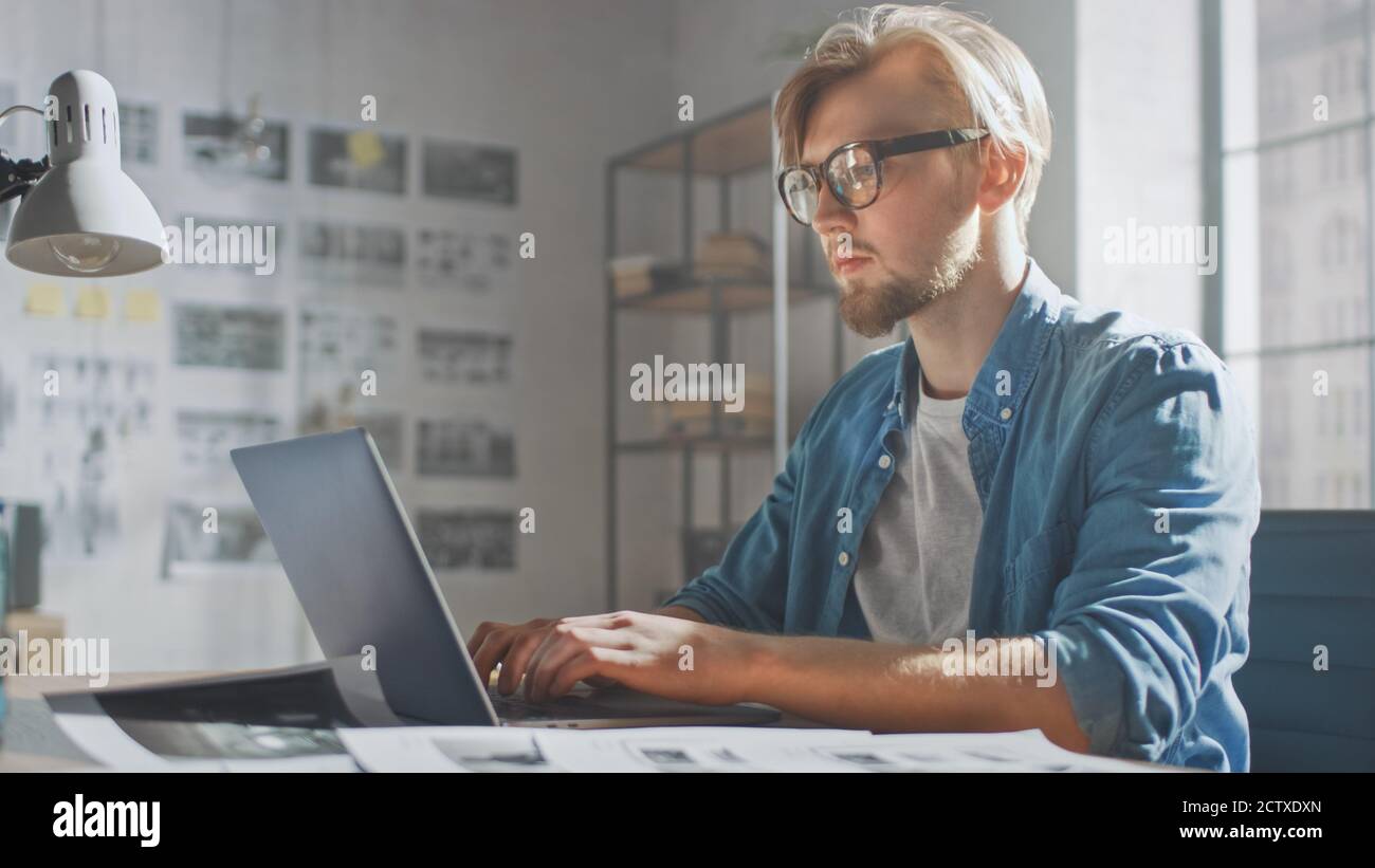 Creative Designer Uses on a Laptop Sitting at His Desk in the Modern ...