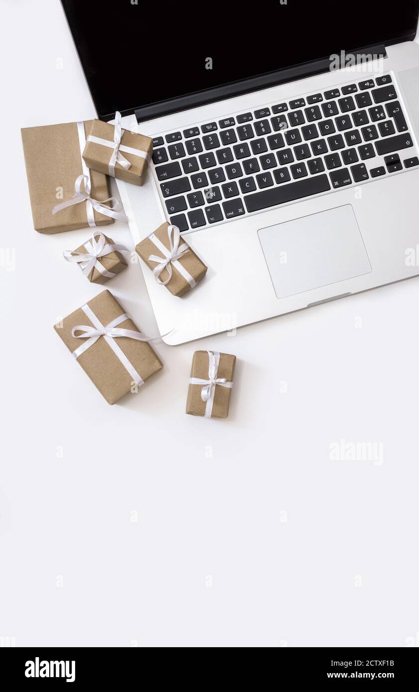 Laptop with gifts and Packing boxes on the white background, top view ...