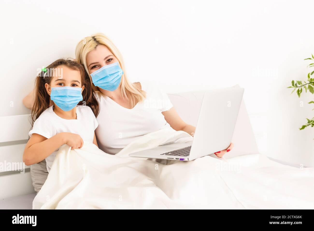 mother and daughter in protective mask at home. Healthcare concept ...