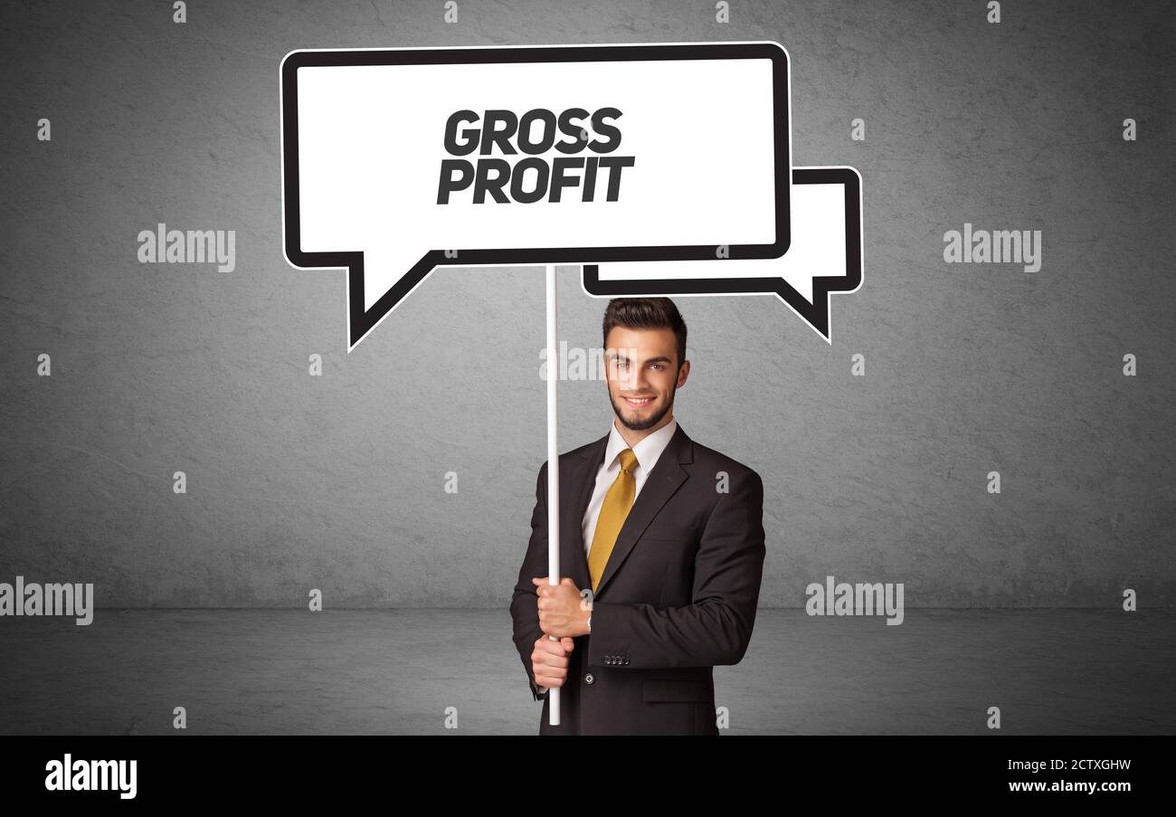 Young business person in casual holding road sign with GROSS PROFIT ...