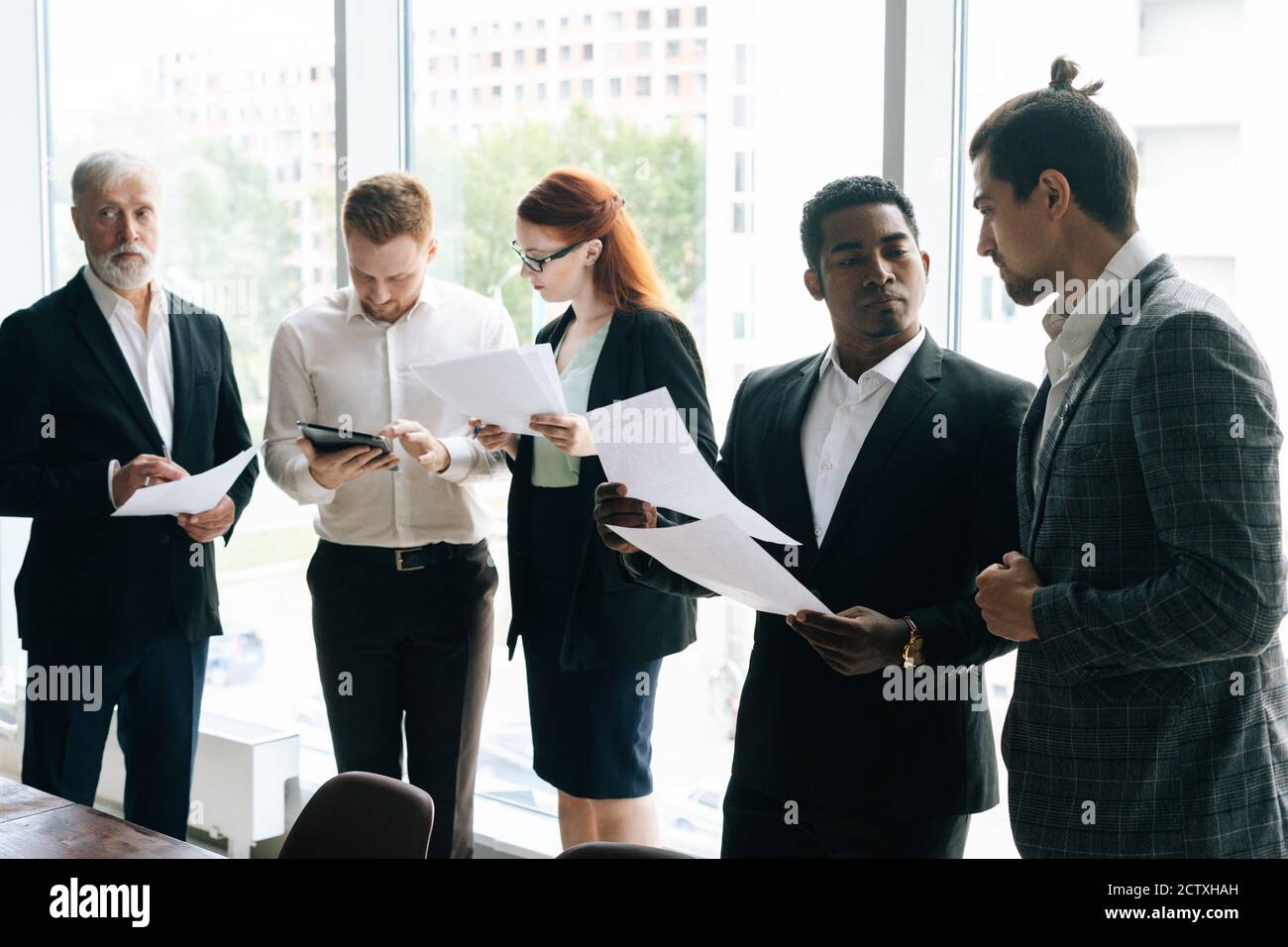 Multinational business team of businessmen and businesswoman studying ...