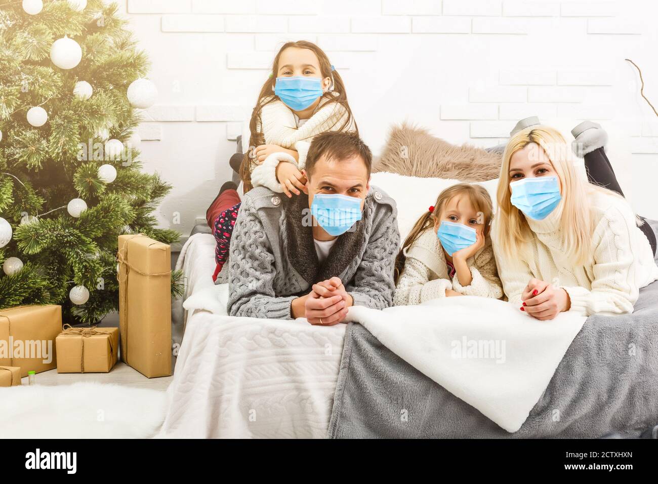 family in protective masks quarantined. Normal life with coronavirus ...
