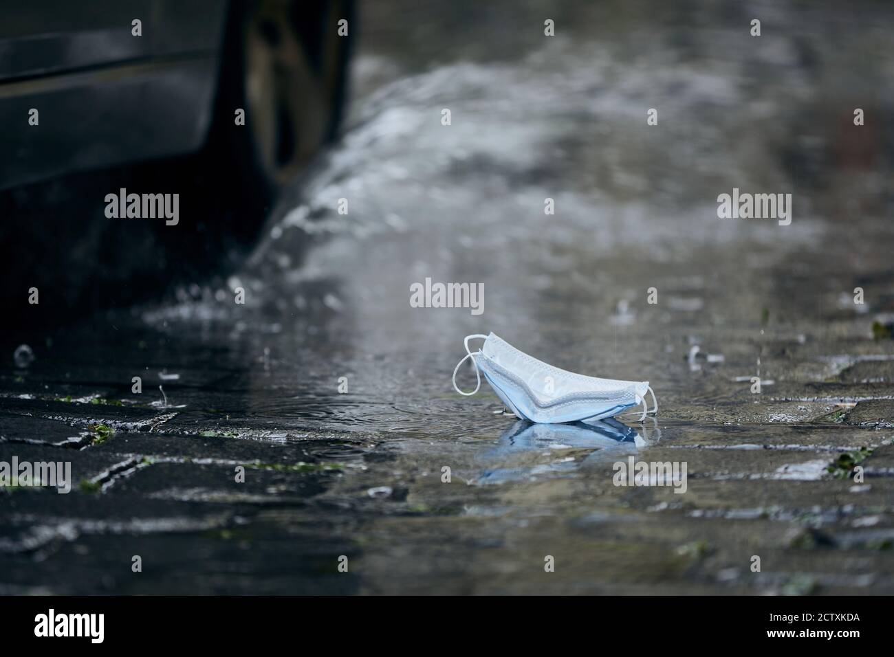 Used disposable face mask in puddle during rain. Themes coronavirus ...