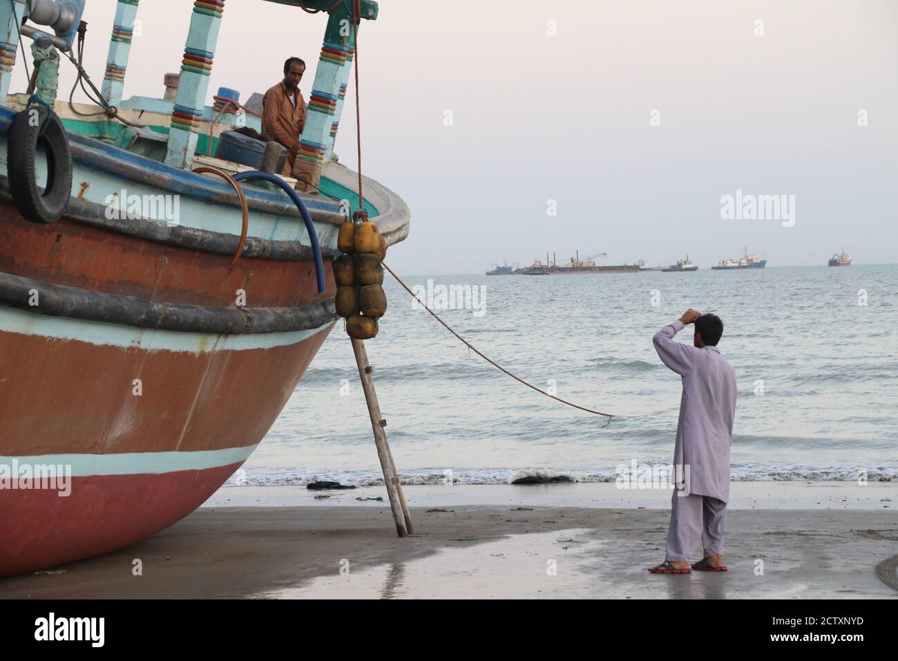 two sailors working on their boat at southern Iran beach Stock Photo ...