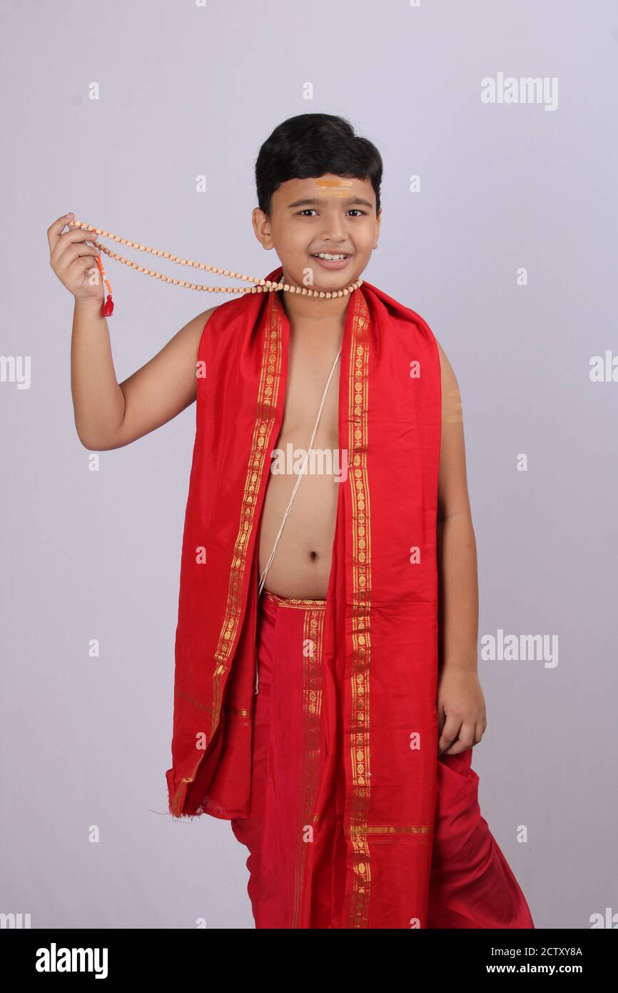 Indian boy in ethnic wear showing off his rosary or string of prayer ...