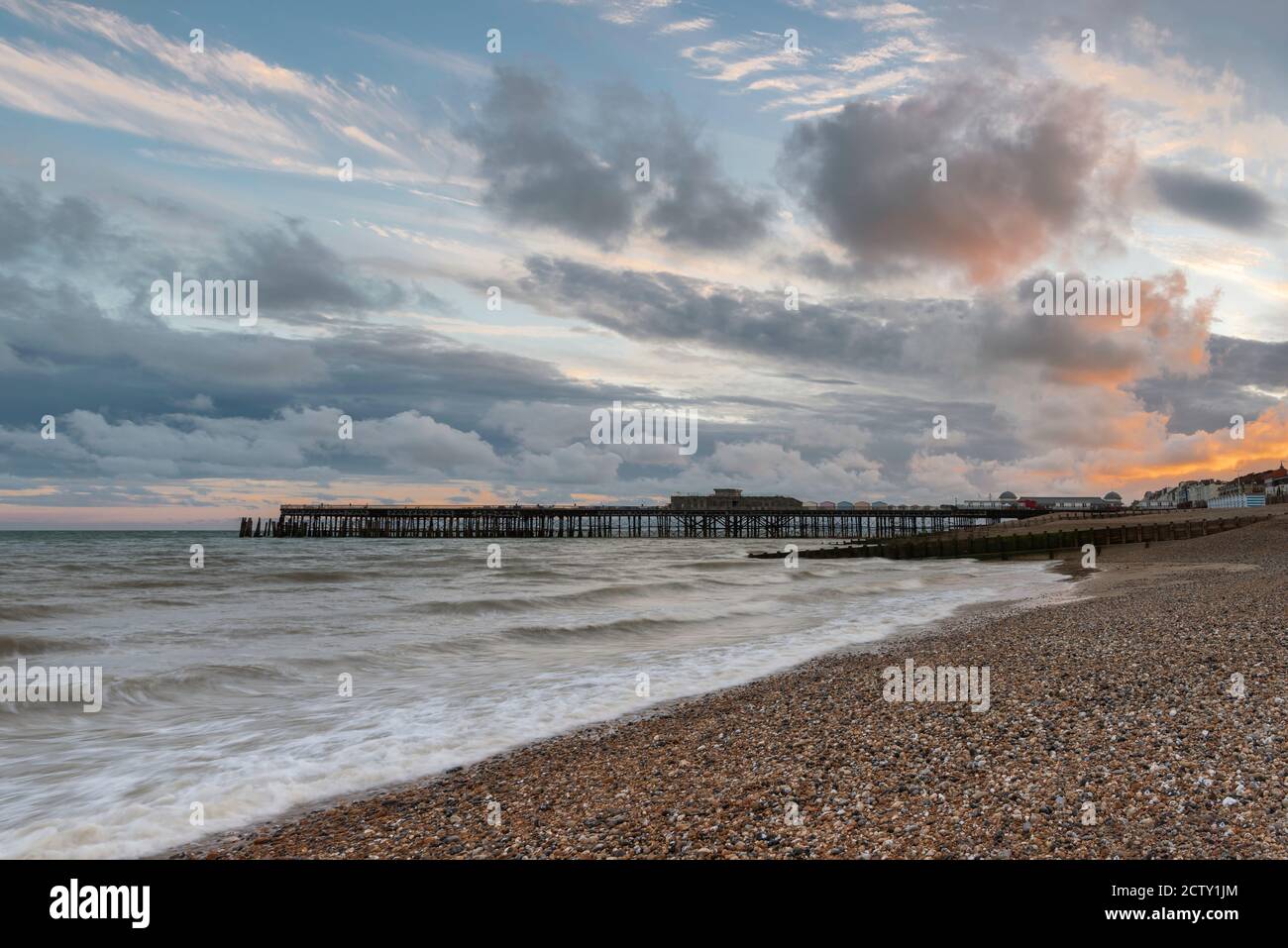Sunset behind Hastings Pier viewed along the beach, East Sussex ...