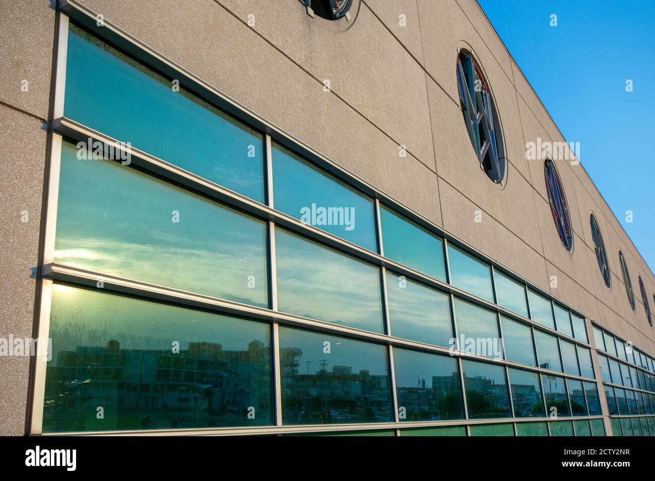 A Tan Building With a Large Window Reflecting the Sunset Sky Stock ...