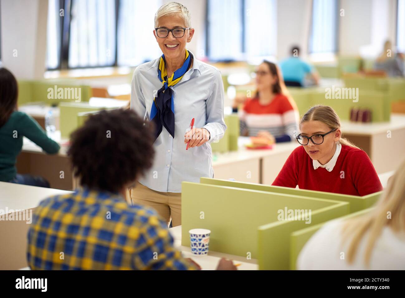 Female professor talking to a student in a classroom Stock Photo - Alamy