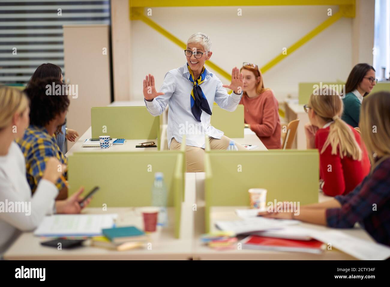 Female professor giving an explanation of the lesson to students at a ...