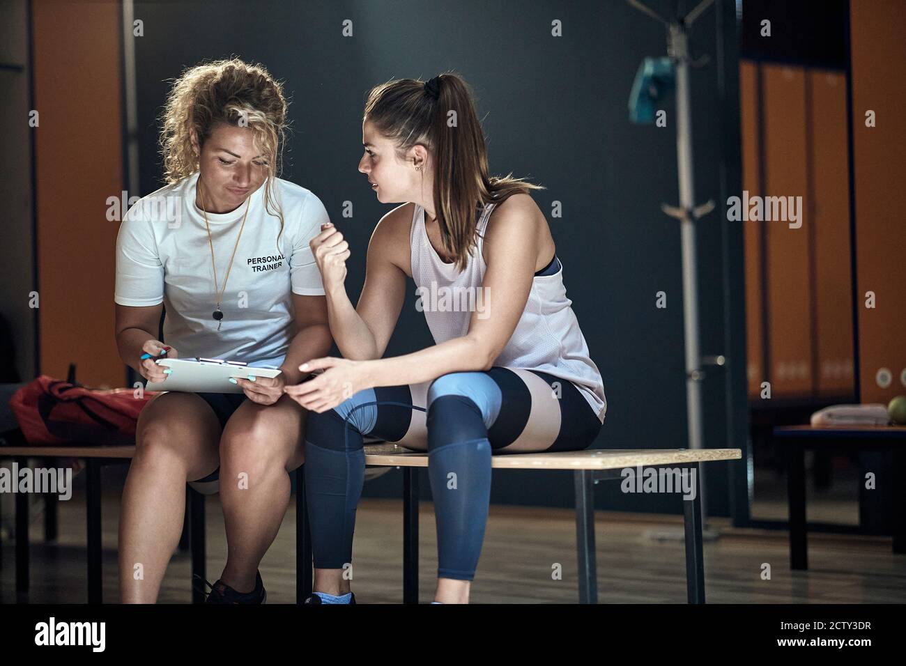 Personal trainer giving advice in a locker room after good training ...