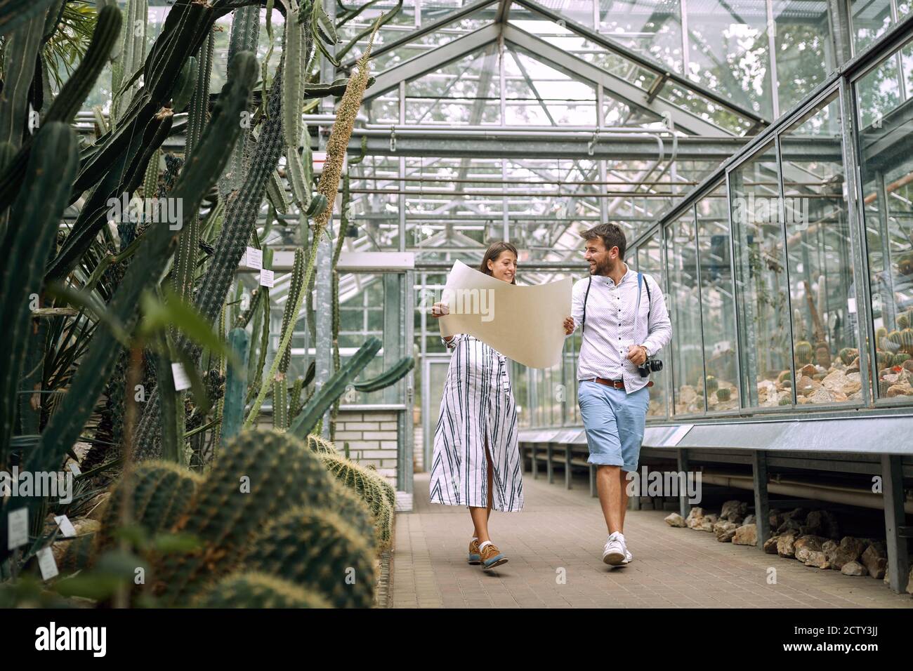Young colleagues walking and observing by following a botanical garden ...