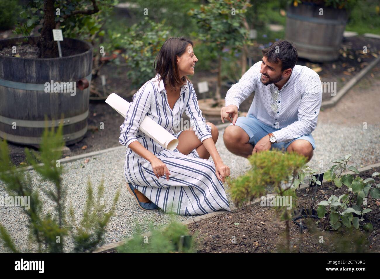Young male visitor asking questions young female guide in a botanical ...
