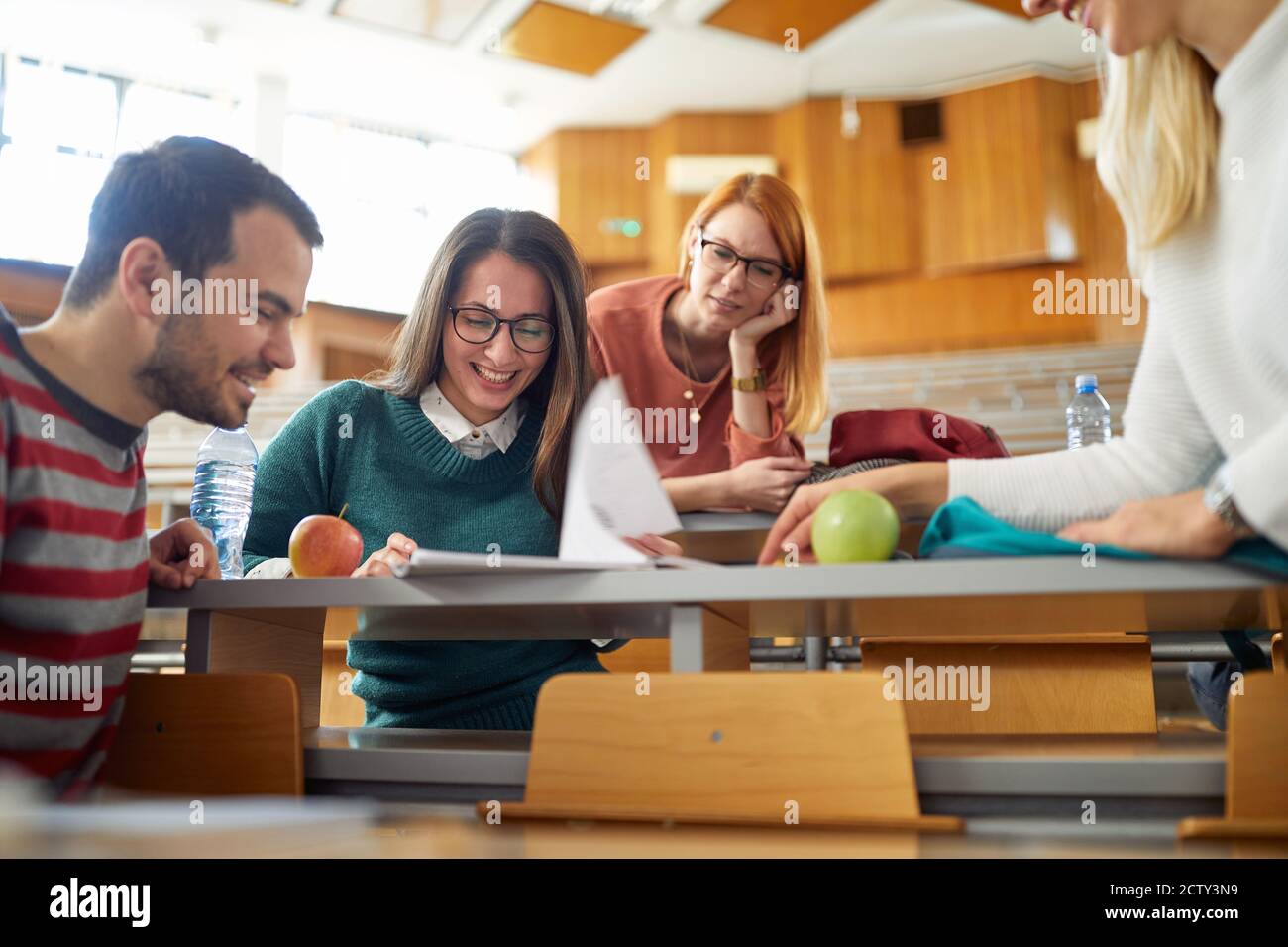 Group of students discussing the lesson on the lecture break in the ...