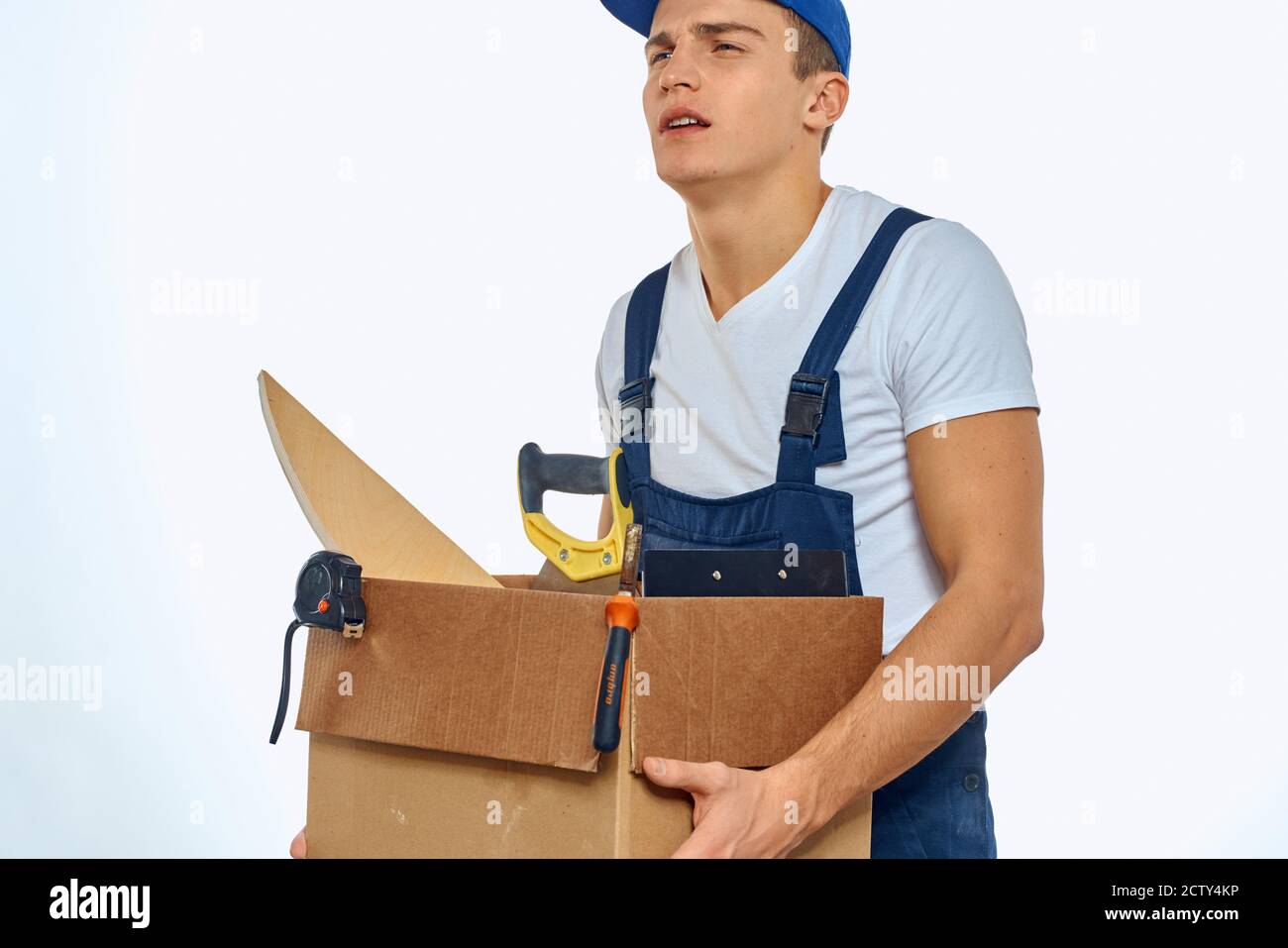 A man in a working uniform with a box in his hand loading a delivery ...