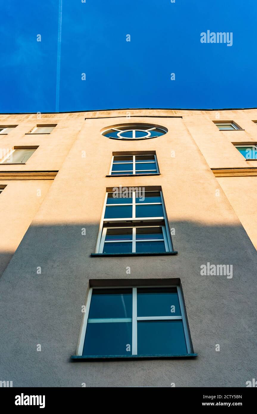 Low angle shot of a modern residential building with blue windows under ...