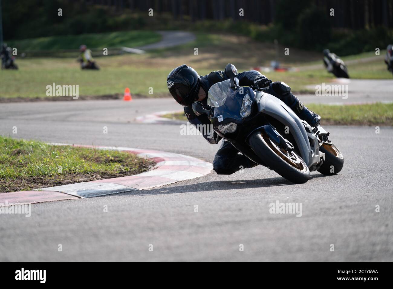 Motorcycle practice leaning into a fast corner on track Stock Photo - Alamy